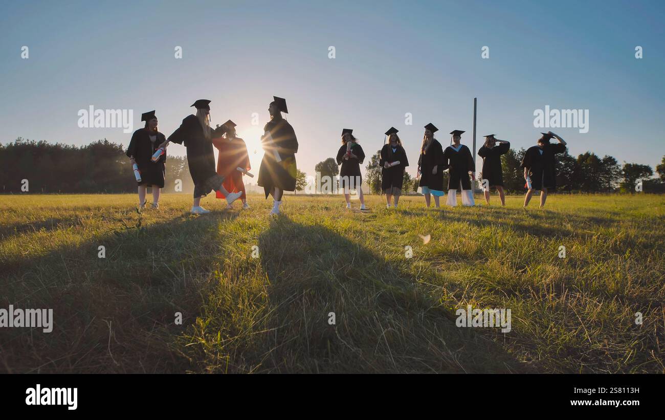 High school graduates celebrating milestones together in a sunlit field ...