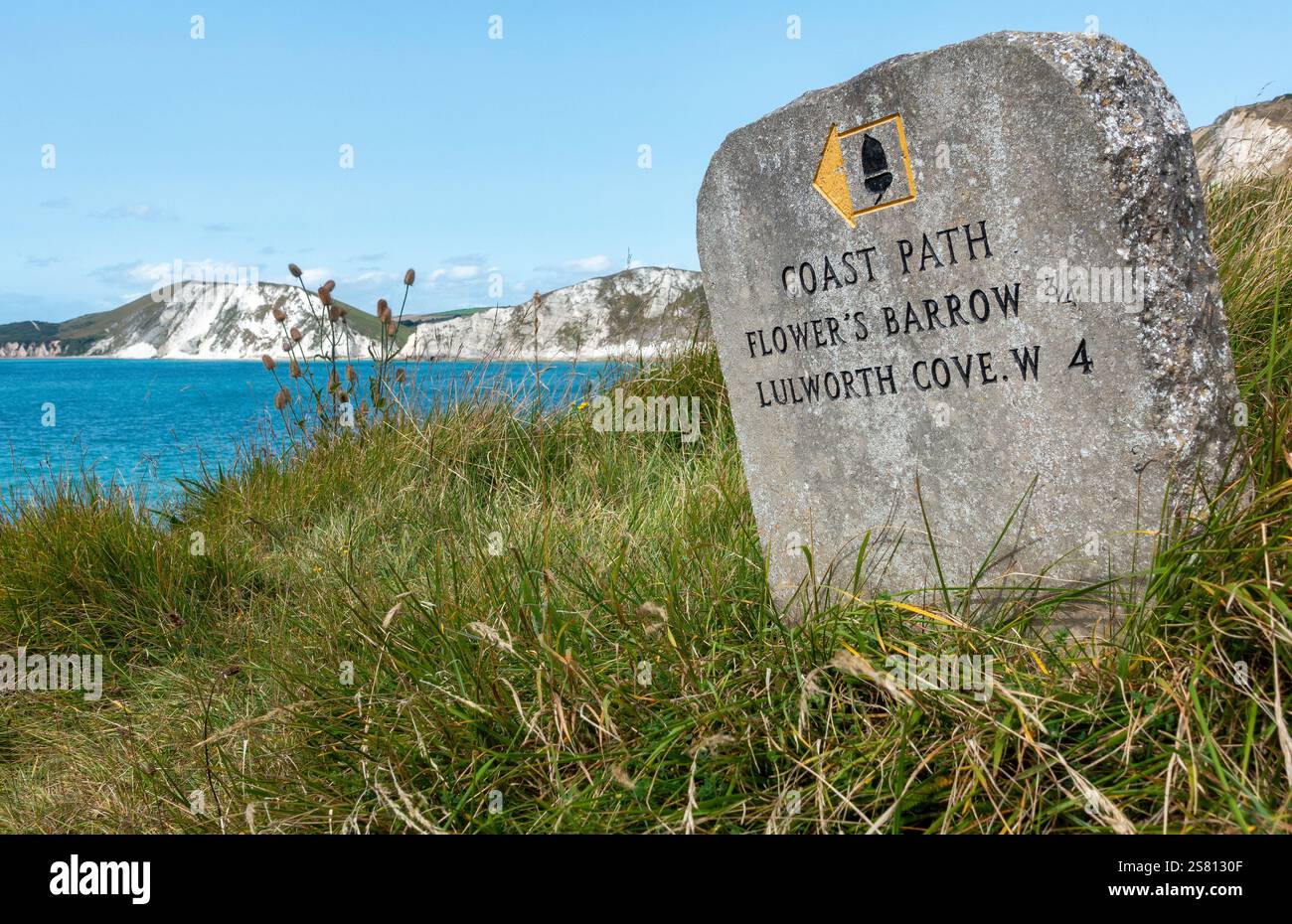 A weathered stone sign marks the coast path leading to Flower's Barrow ...