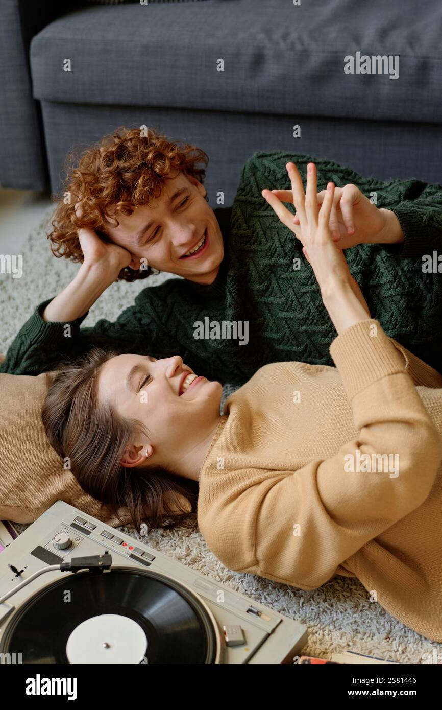 Vertical high angle shot of Caucasian girlfriend and boyfriend lying on ...