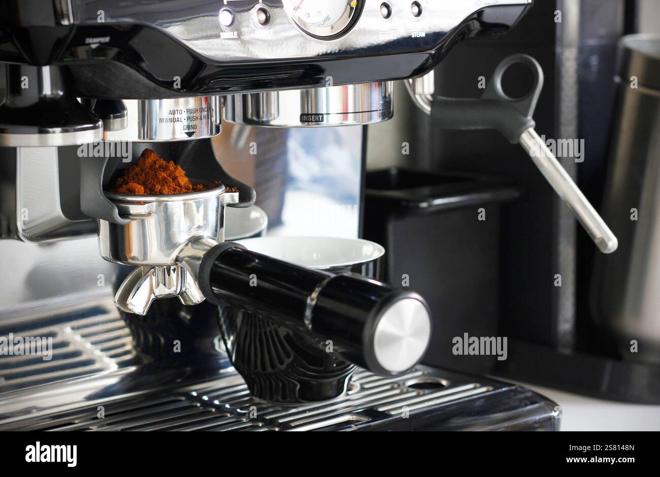 Close-up of freshly ground coffee beans in a portafilter as part of the ...