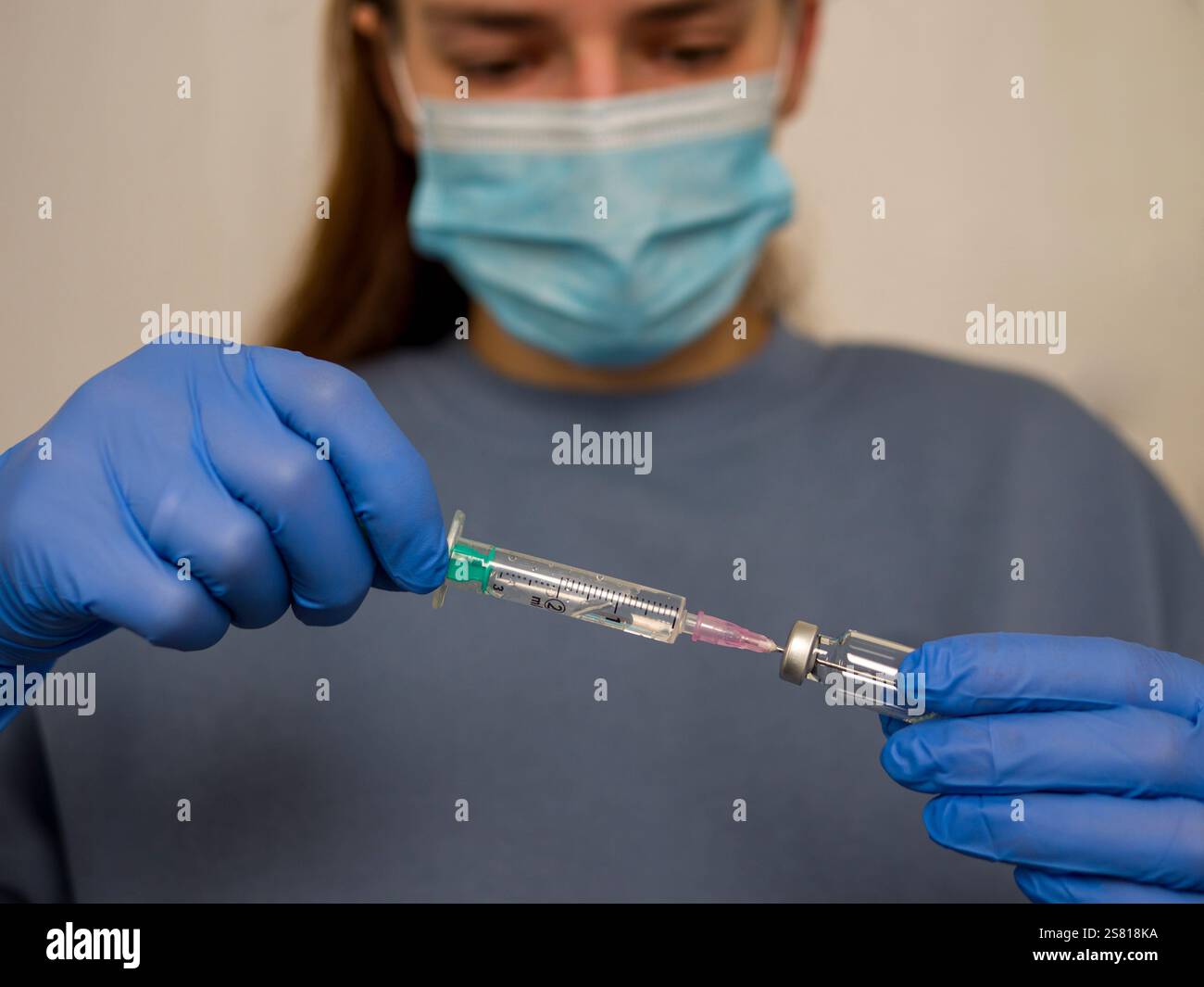 Female nurse preparing covid-19 vaccine, wearing protective medical ...