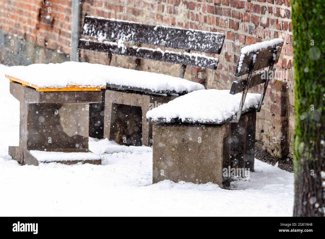 A bench and a table covered in snow. The scene is quiet and peaceful ...
