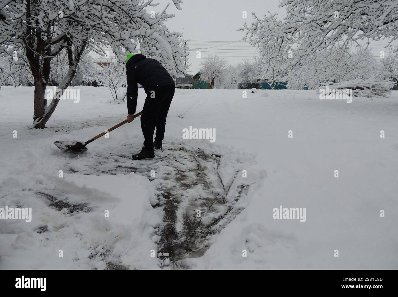 man clearing path in front yard, snow shoveling on driveway to private ...