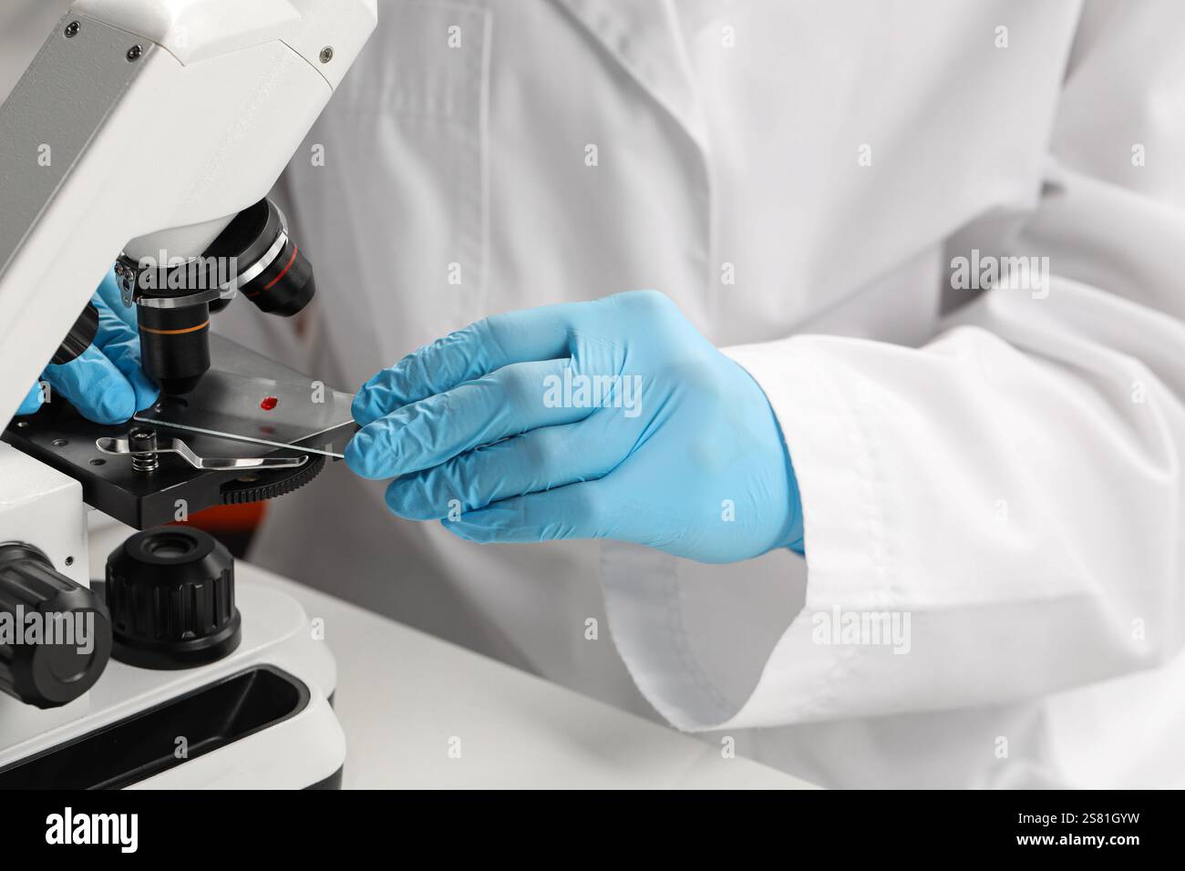 Scientist examining sample on slide under microscope, closeup Stock ...