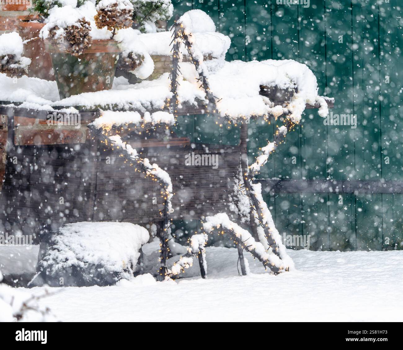 A snow-covered star is lit up in the snow, creating a warm and festive ...