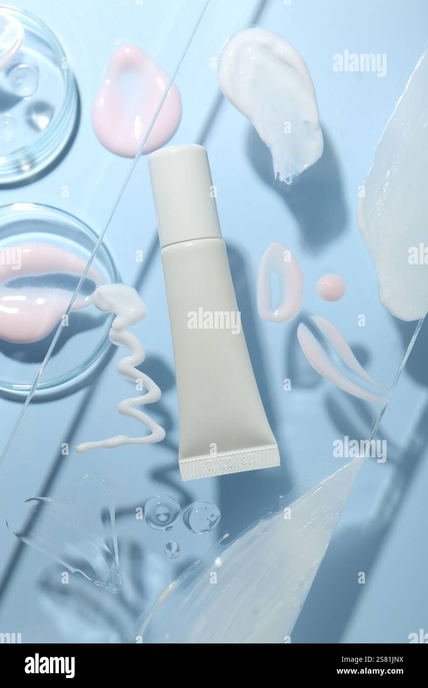 Cream and gel samples on light blue background, flat lay. Stylish ...