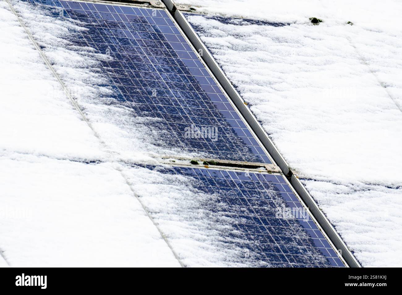 A solar panel covered in snow. The snow is covering the panel in a way ...