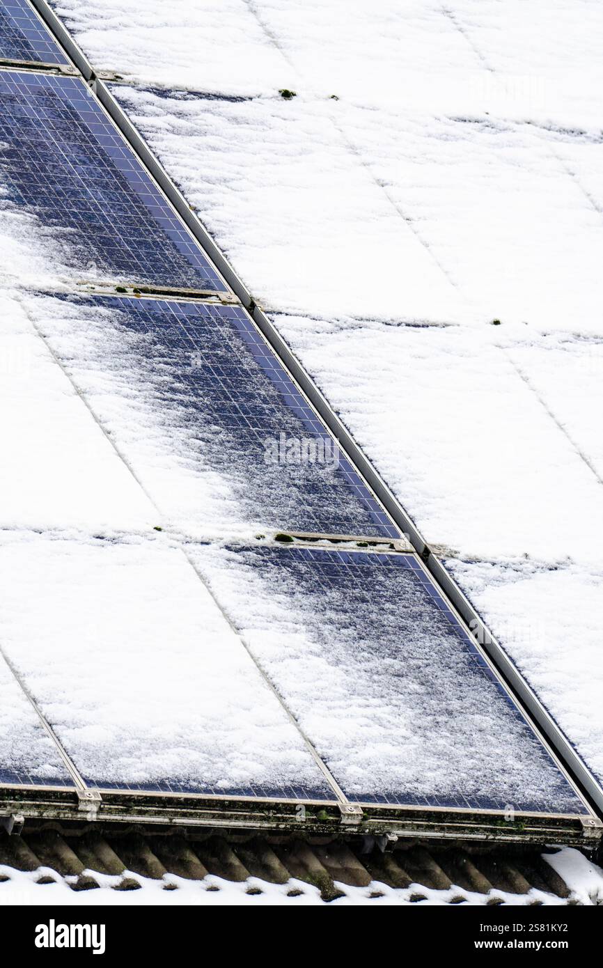 A solar panel covered in snow. The snow is covering the panel in a way ...