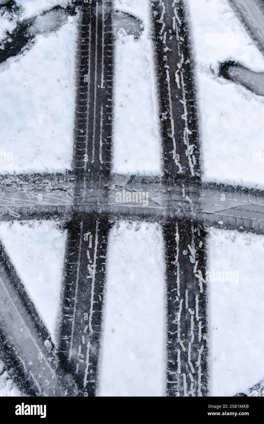A tire track in the snow, with the tire tracks forming an X shape. The ...