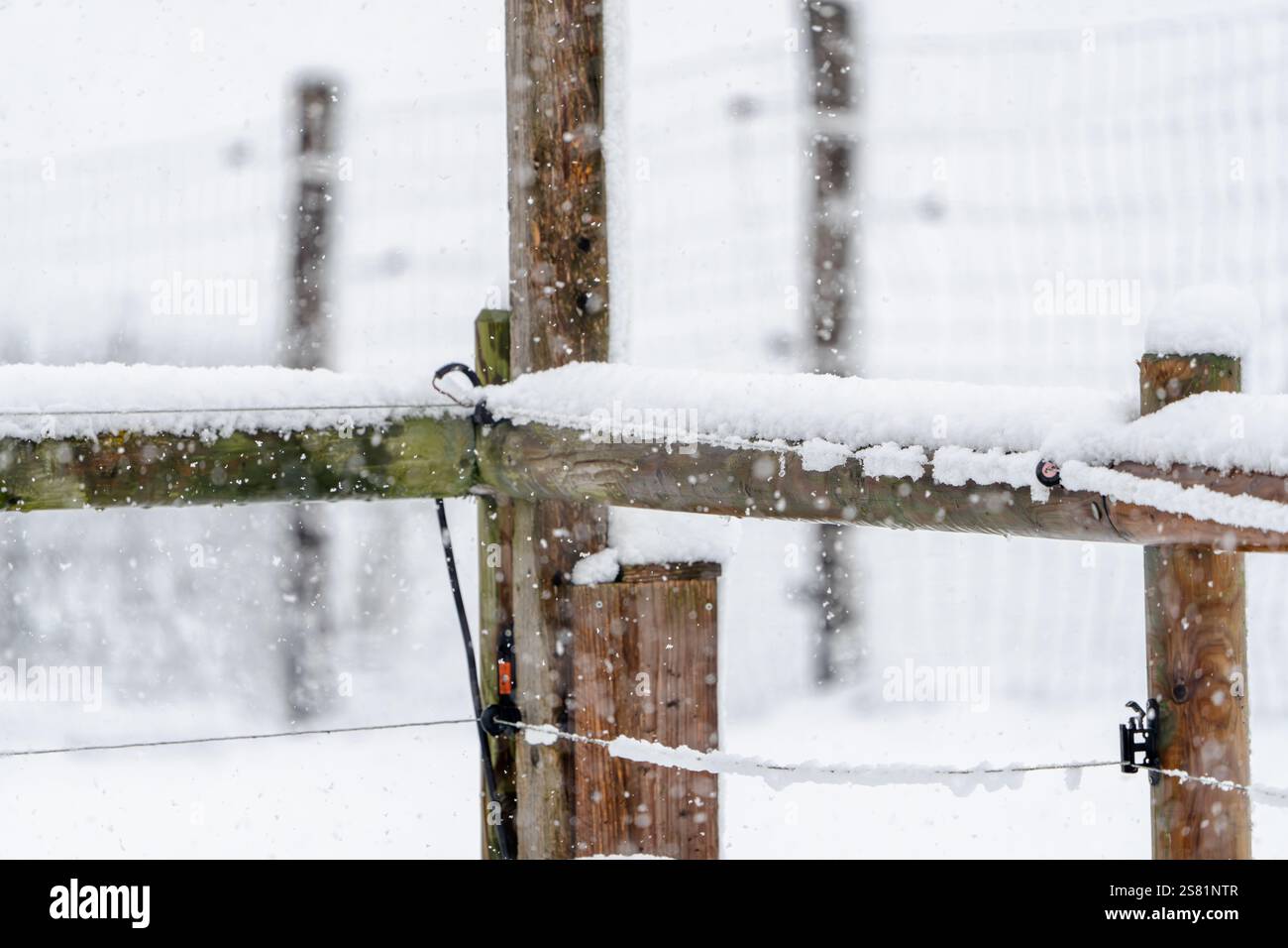 A wooden fence with snow on it. The fence is in a rural area. The snow ...
