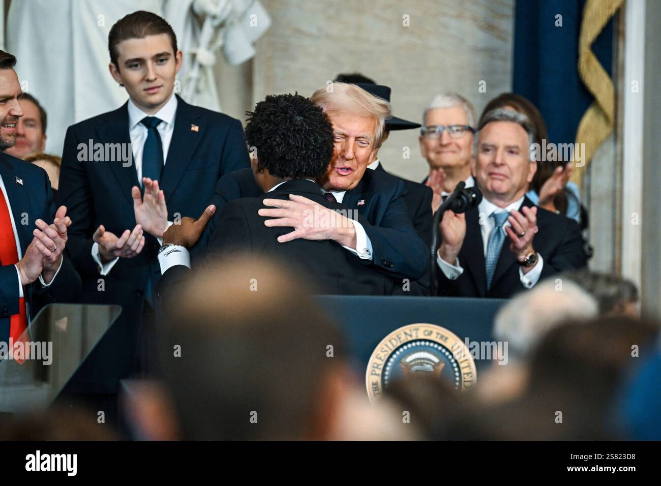 Senior Pastor Lorenzo Sewell, second left, hugs President Donald Trump ...