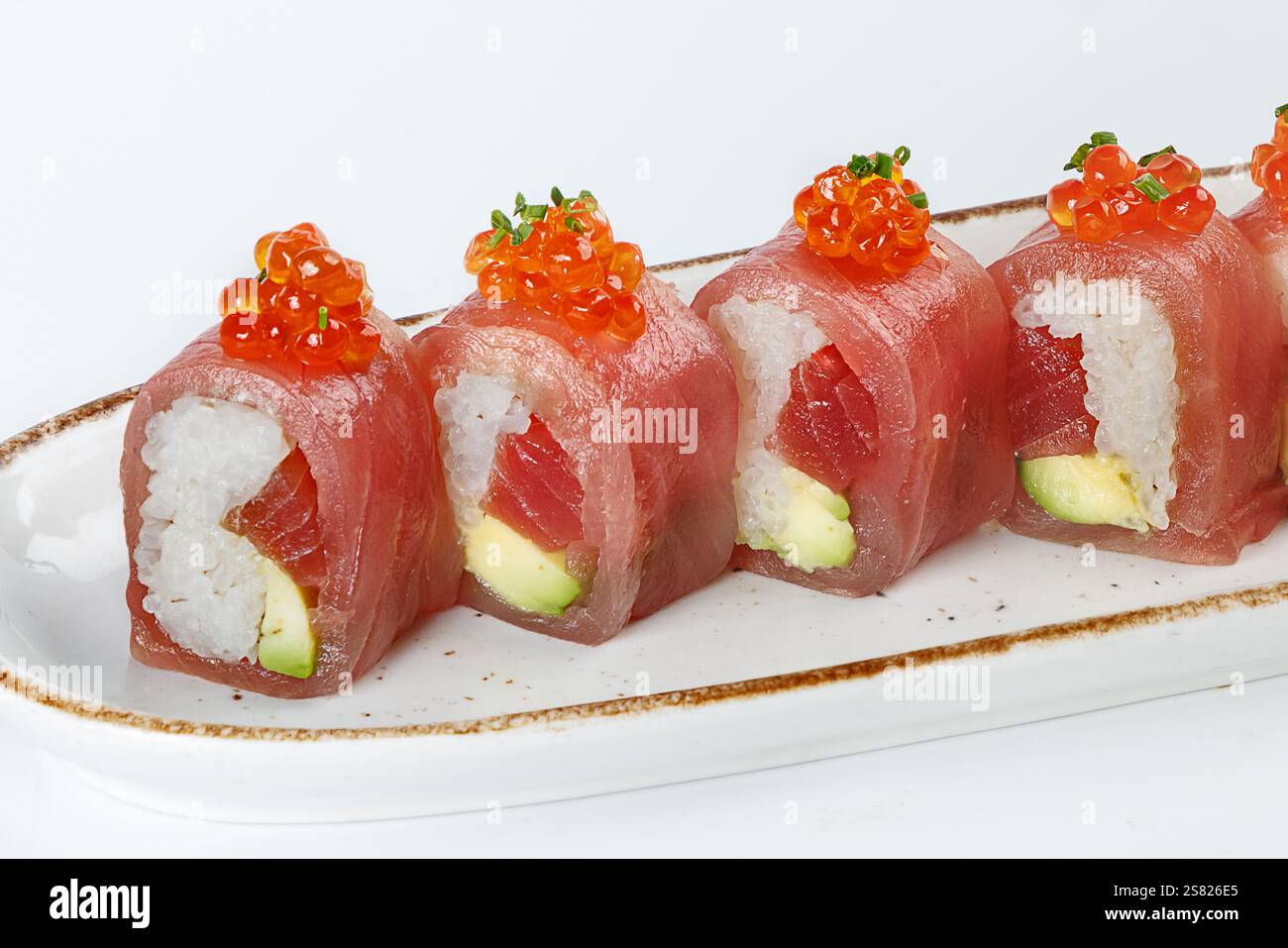 Ceramic tray with variety of tuna sushi roll with avocado, appetizing ...