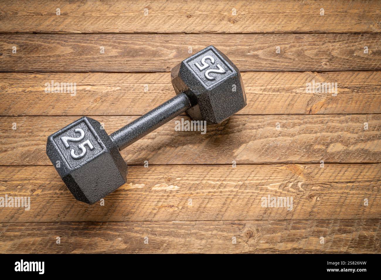 heavy cast iron hex dumbbell on a grained barn wood background, fitness ...