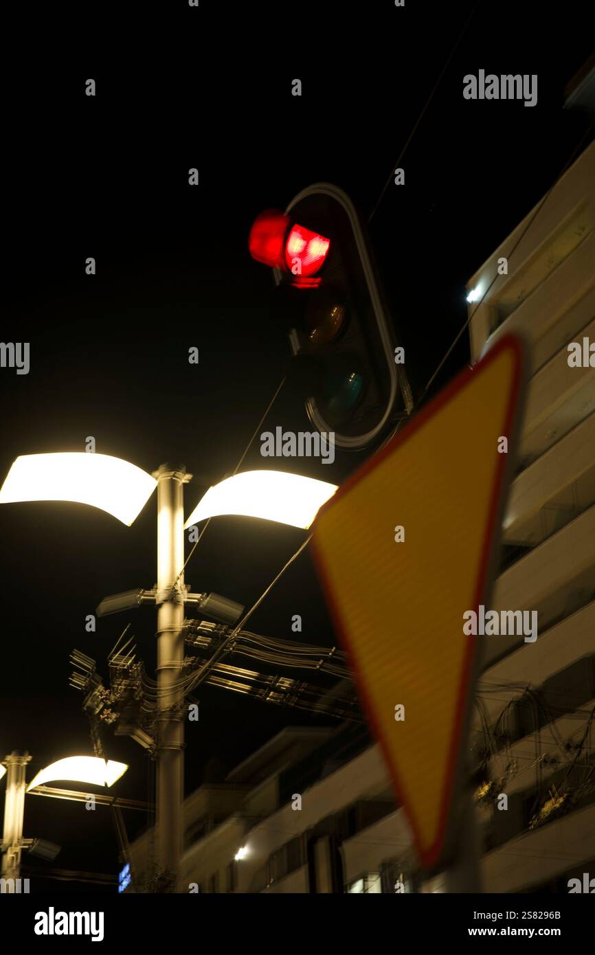 A red traffic light shines at night with a cinematic angle, featuring a ...