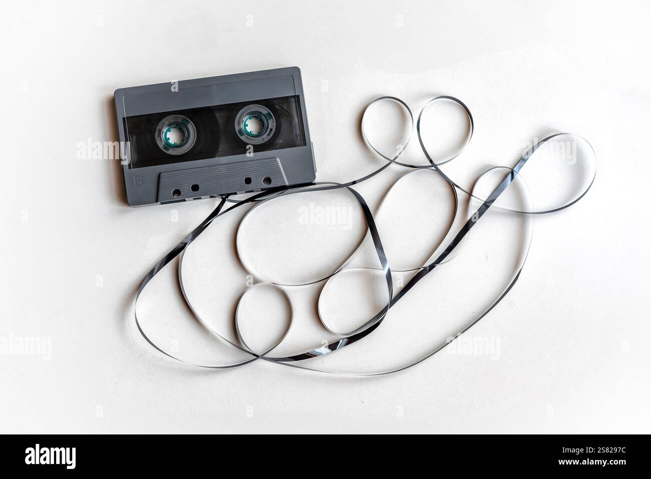 Tangled cassette tape spilling onto a white surface. A nostalgic image ...