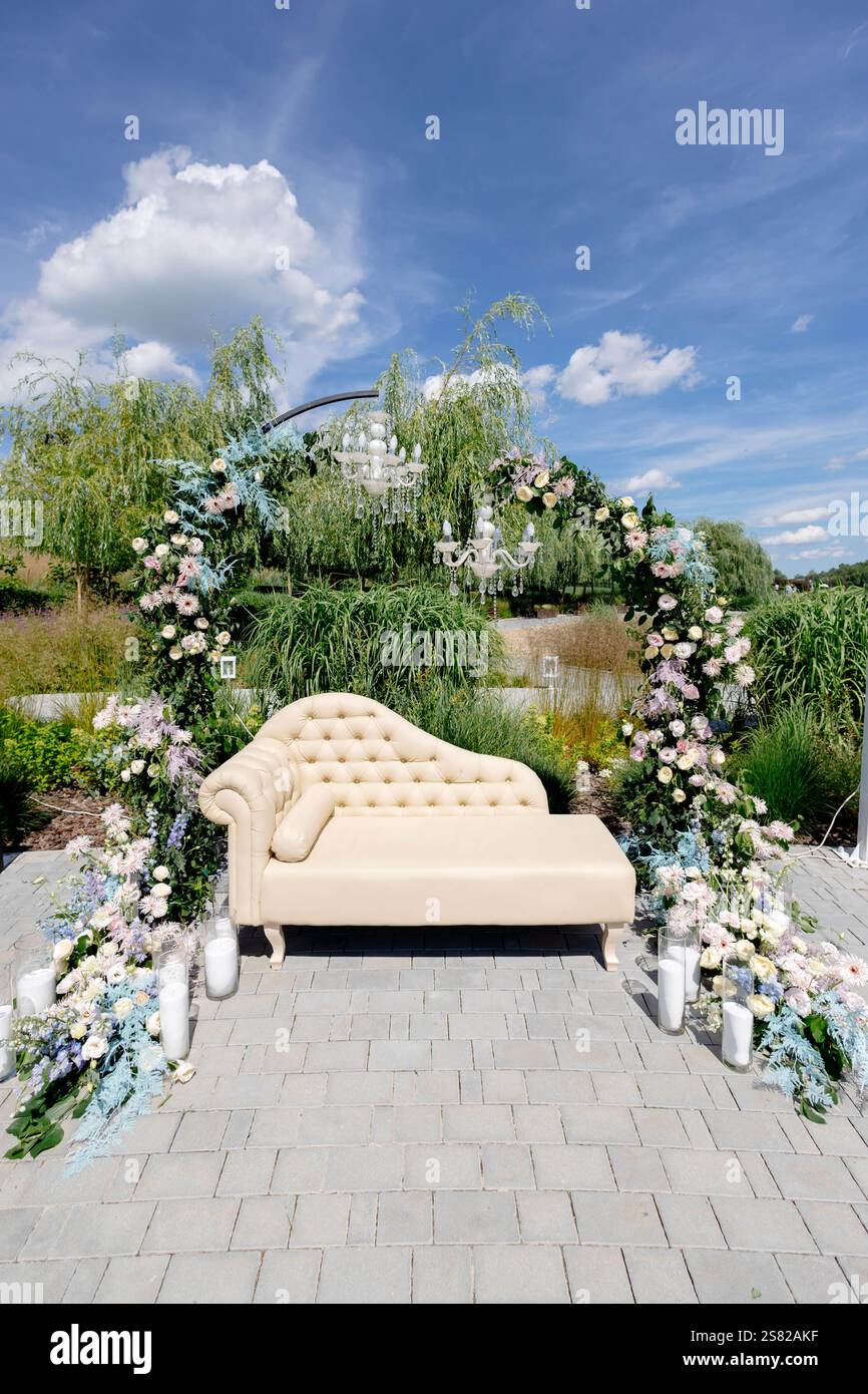 Luxurious wedding setup featuring a beige chaise lounge beneath a ...