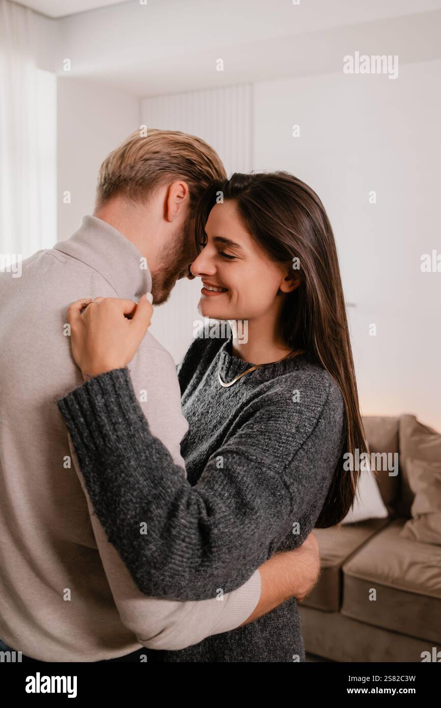 Couple embracing warmly in a cozy and modern home interior setting ...