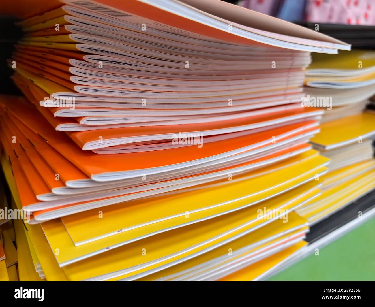 A collection of brightly colored notebooks in shades of orange and ...
