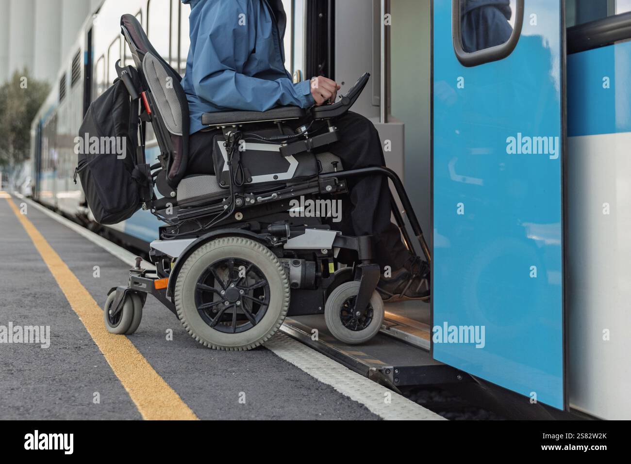 Man with disability on electric wheelchair entering a train. Accessible ...