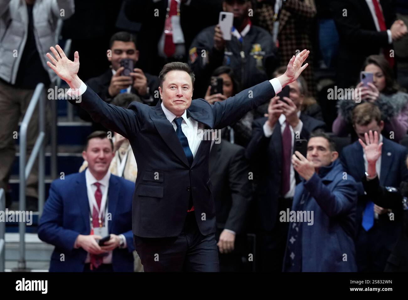 Elon Musk arrives on stage to speak at an indoor Presidential ...