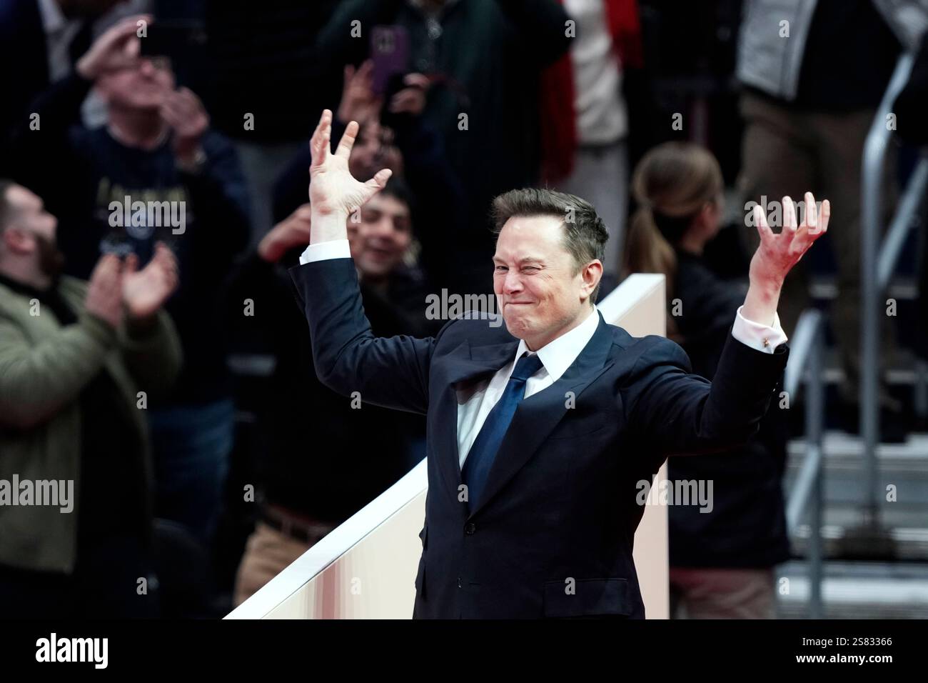 Elon Musk arrives on stage to speak at an indoor Presidential ...