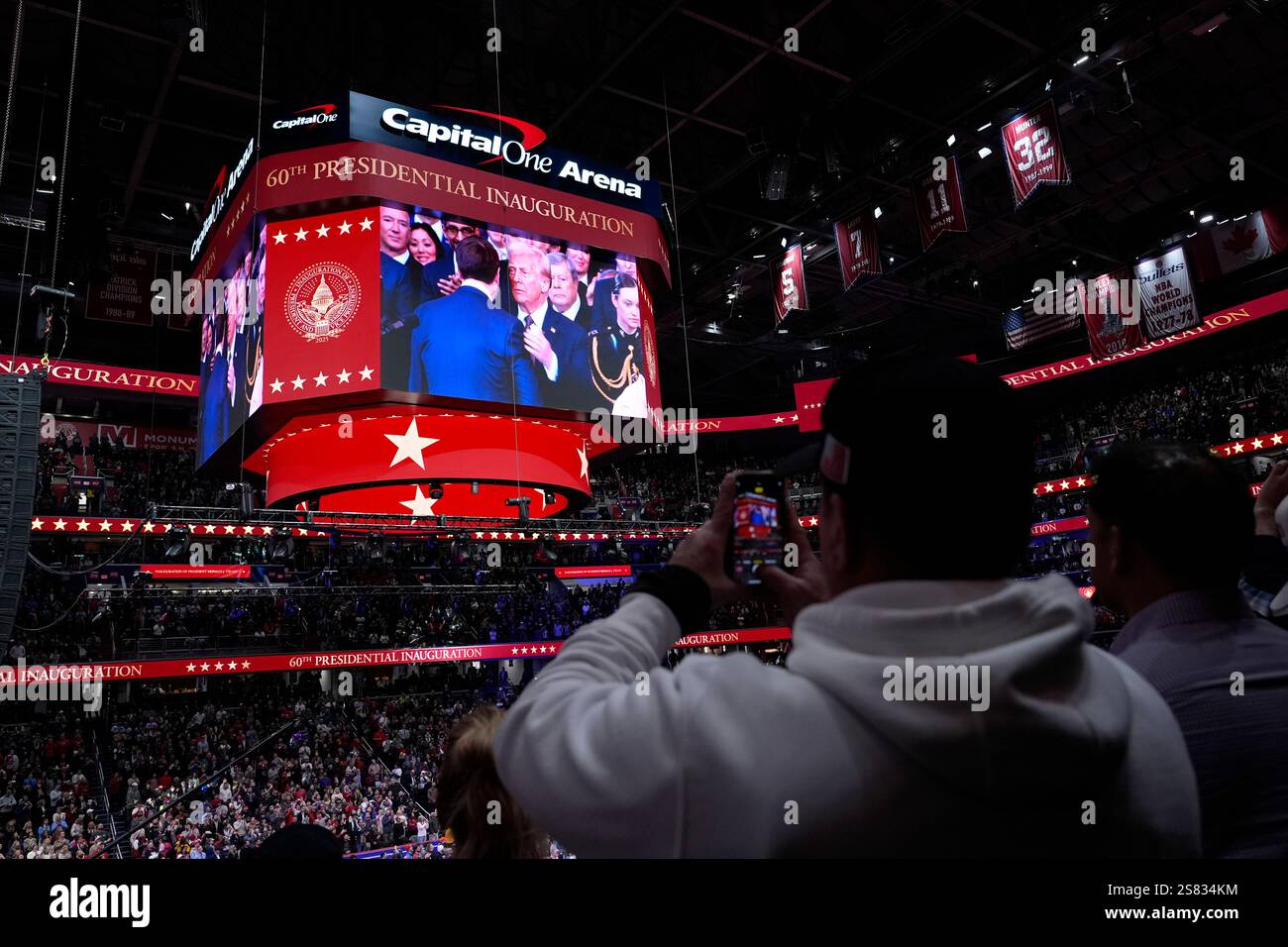 People watch a big screen from the arena site of an indoor Presidential ...