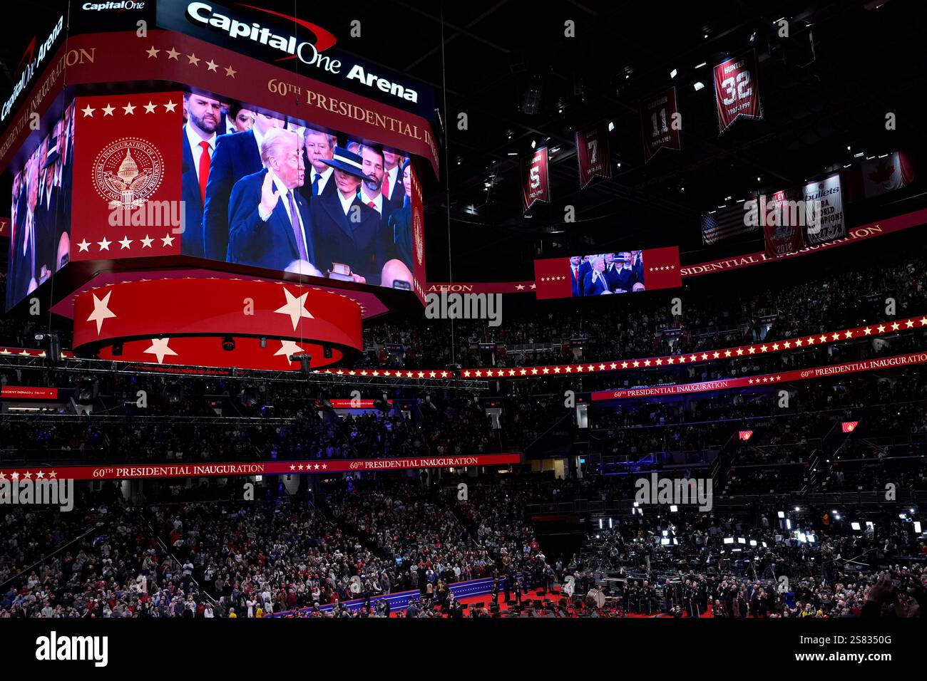 People watch a big screen from the arena site of an indoor Presidential ...
