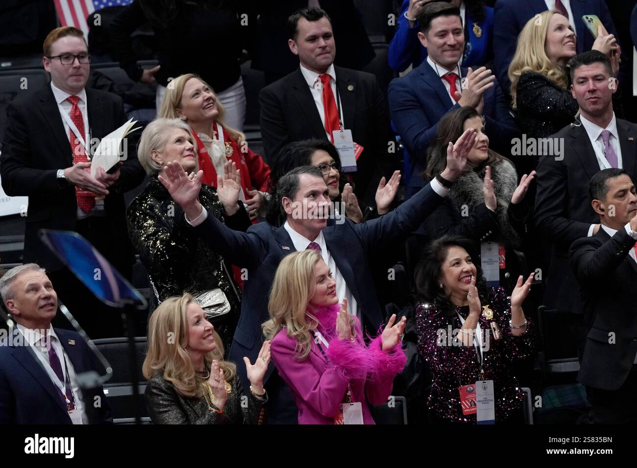 People react as they watch a big screen from the arena site of an ...