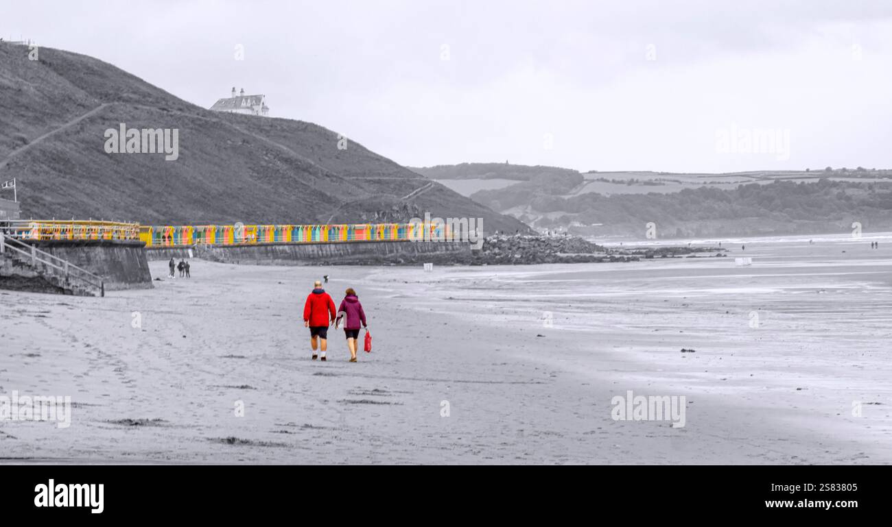 Multi-coloured beach huts reflected in the beach puddles on Whitby ...