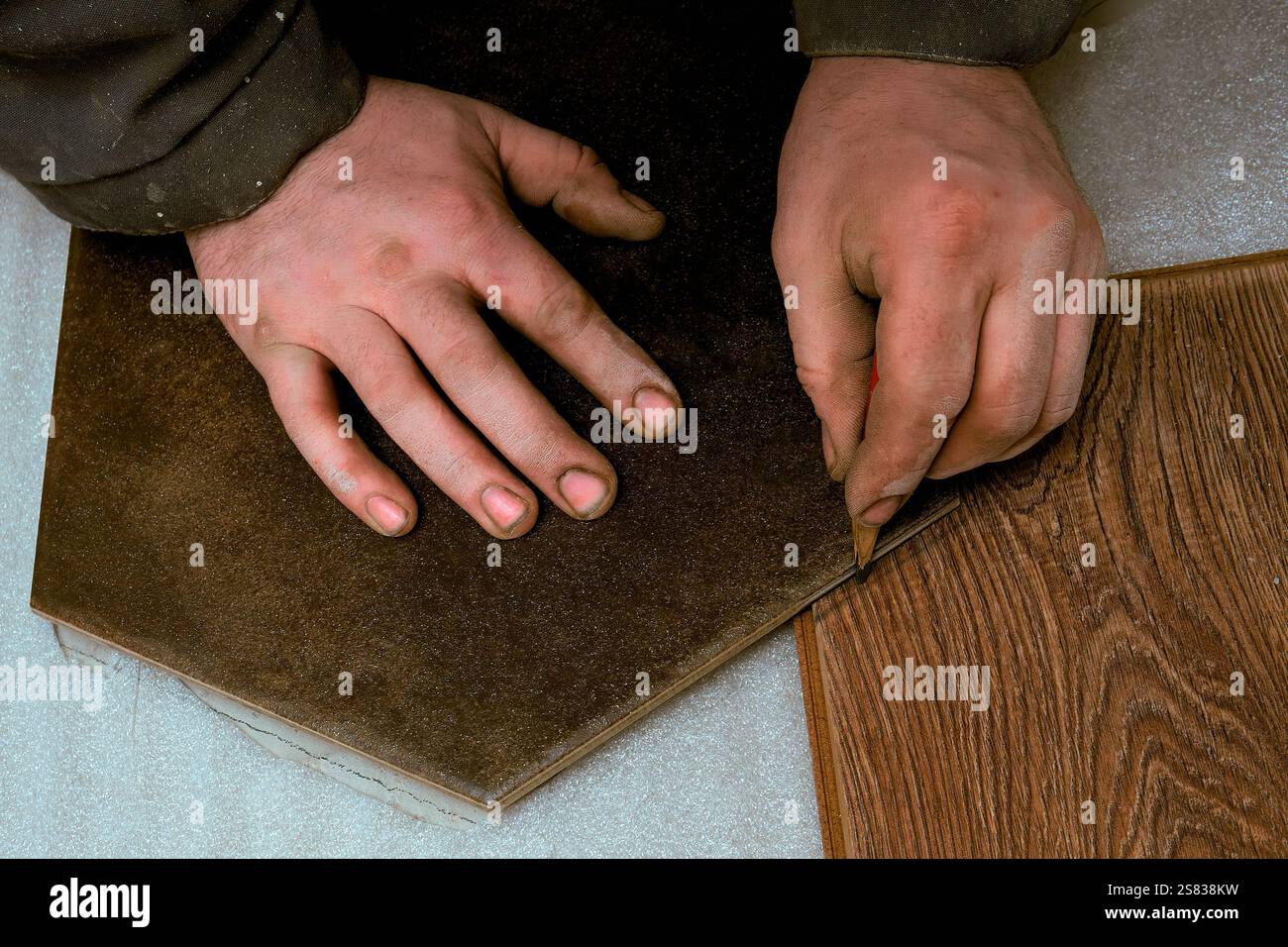 In a cozy workshop, skilled hands meticulously mark out designs on ...