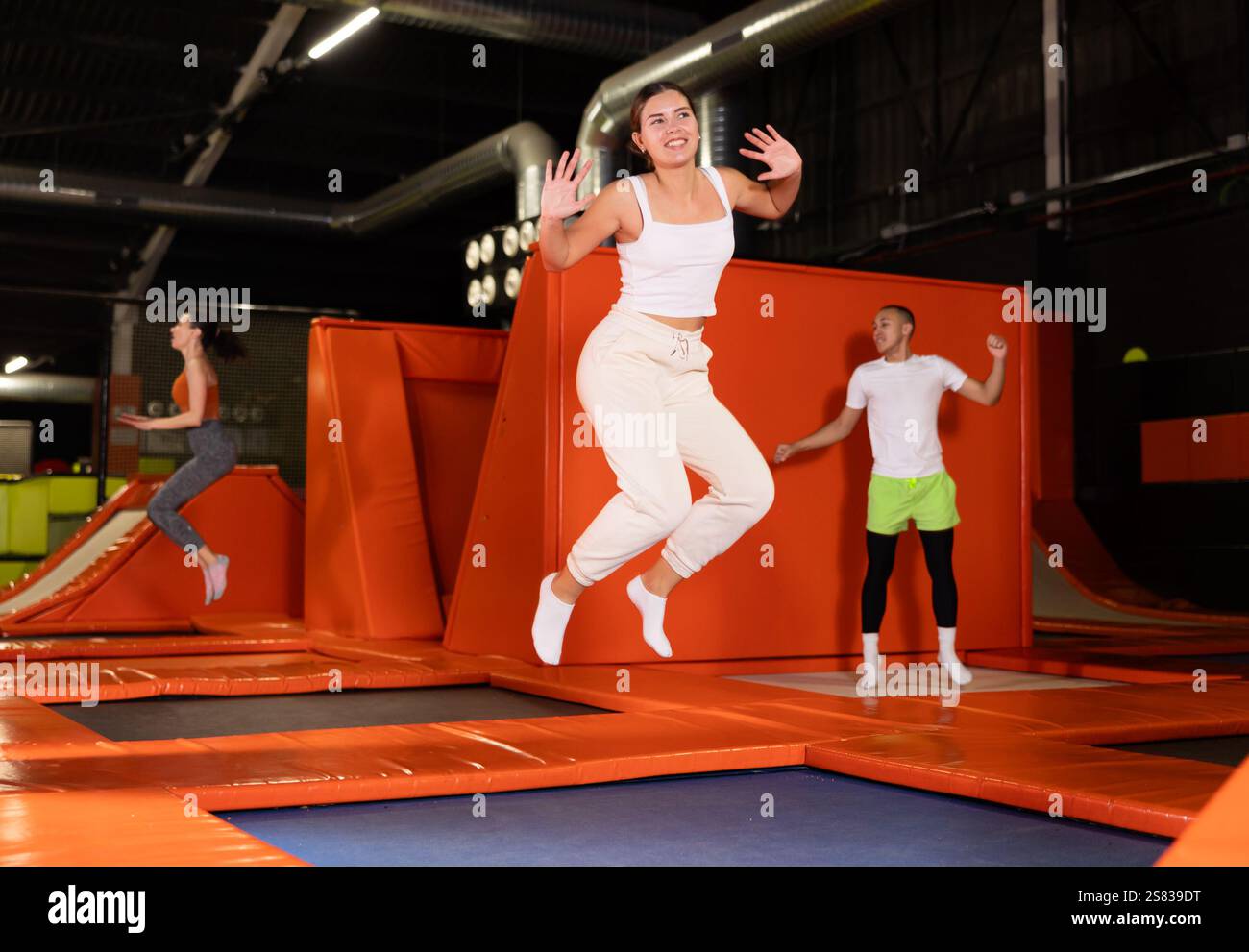 Happy girl bouncing on trampoline in indoor amusement park Stock Photo ...