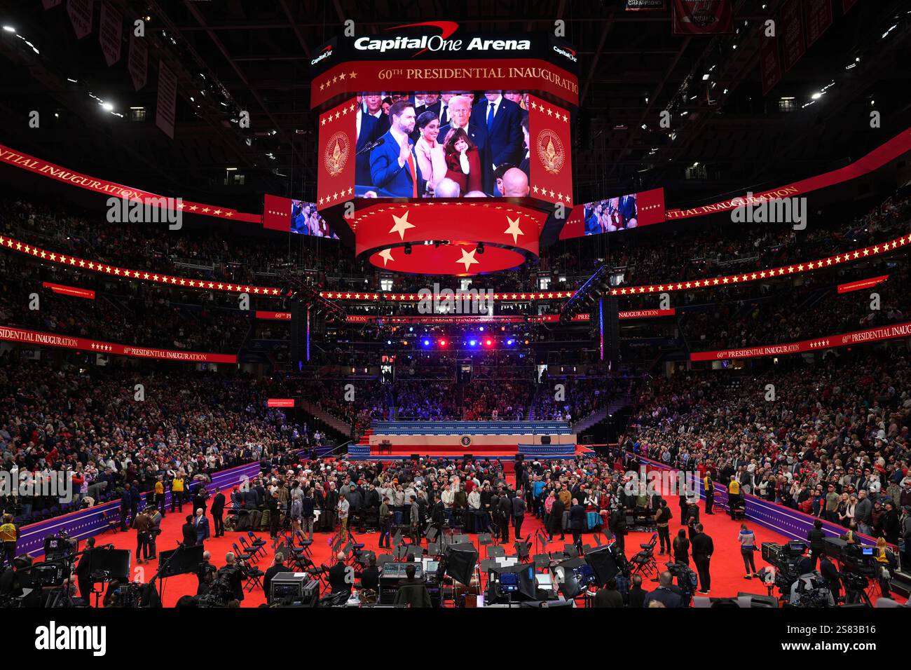 Attendees watch at an Inauguration parade as a screen shows Vice ...