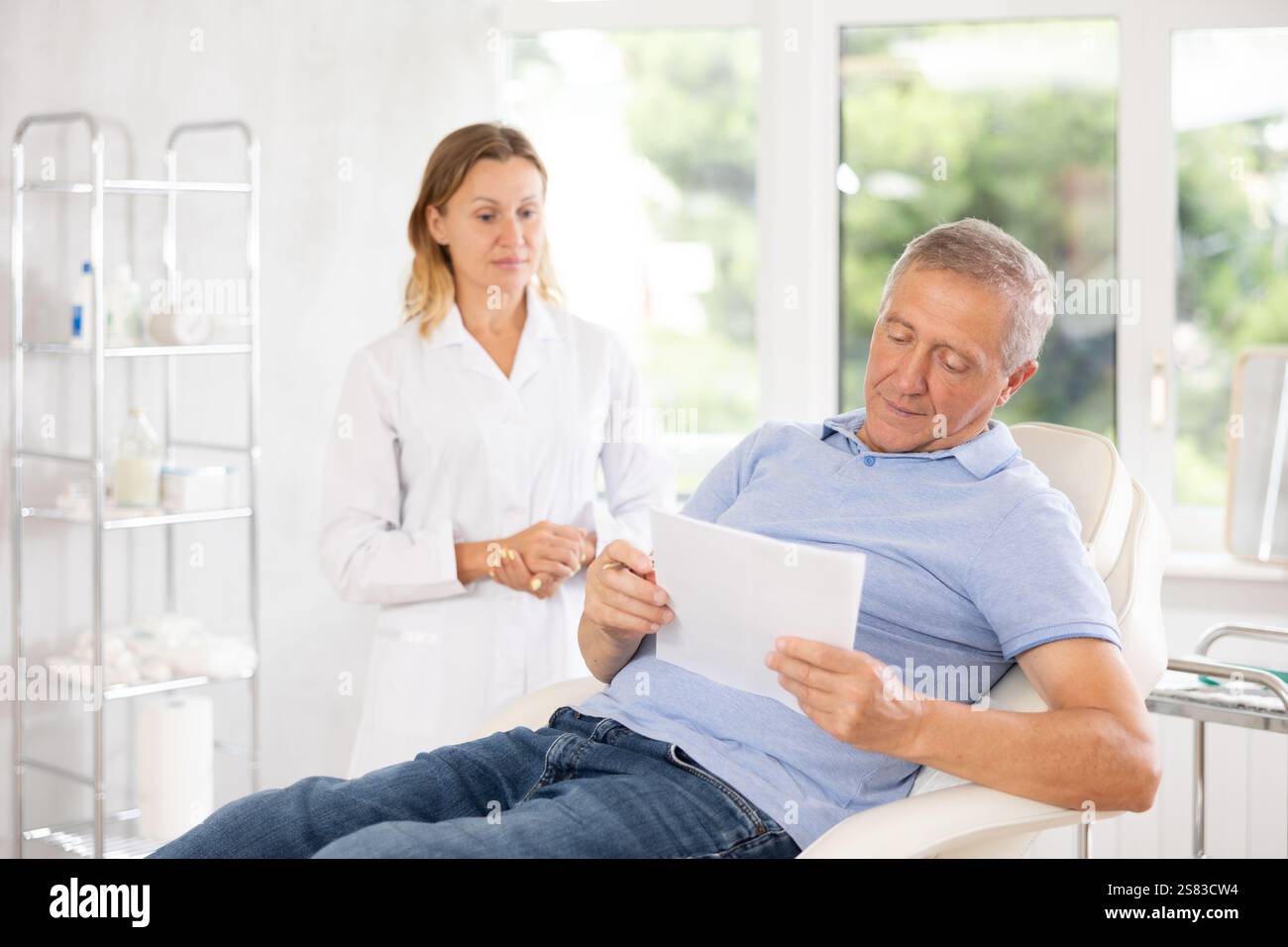 Elderly patient signing informed consent form during medical ...