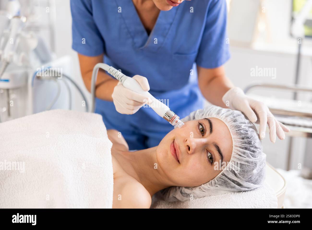 Woman undergoing cosmetic facial treatment using ion bubble attachment ...