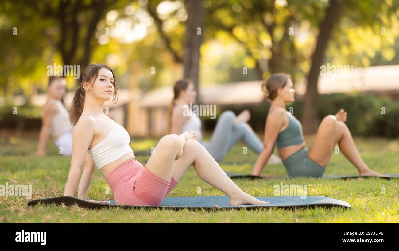 Group of young women doing stretching in park Stock Photo - Alamy