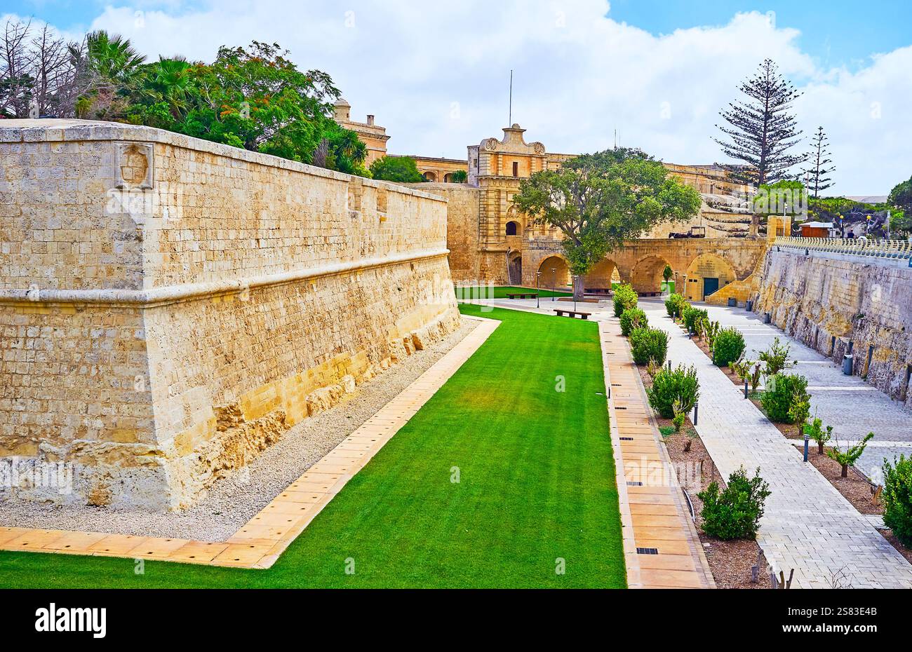 The scenic ornamental park in historic moat between the walls of Mdina ...