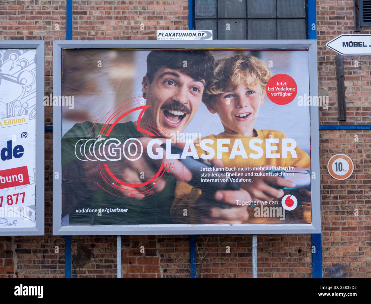 Werbeplakat für Glasfaser von Vodafone an der Wand von einem ...