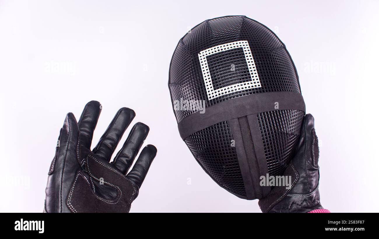 POV view of hands of Squid Game pink guard holding a mask on white ...