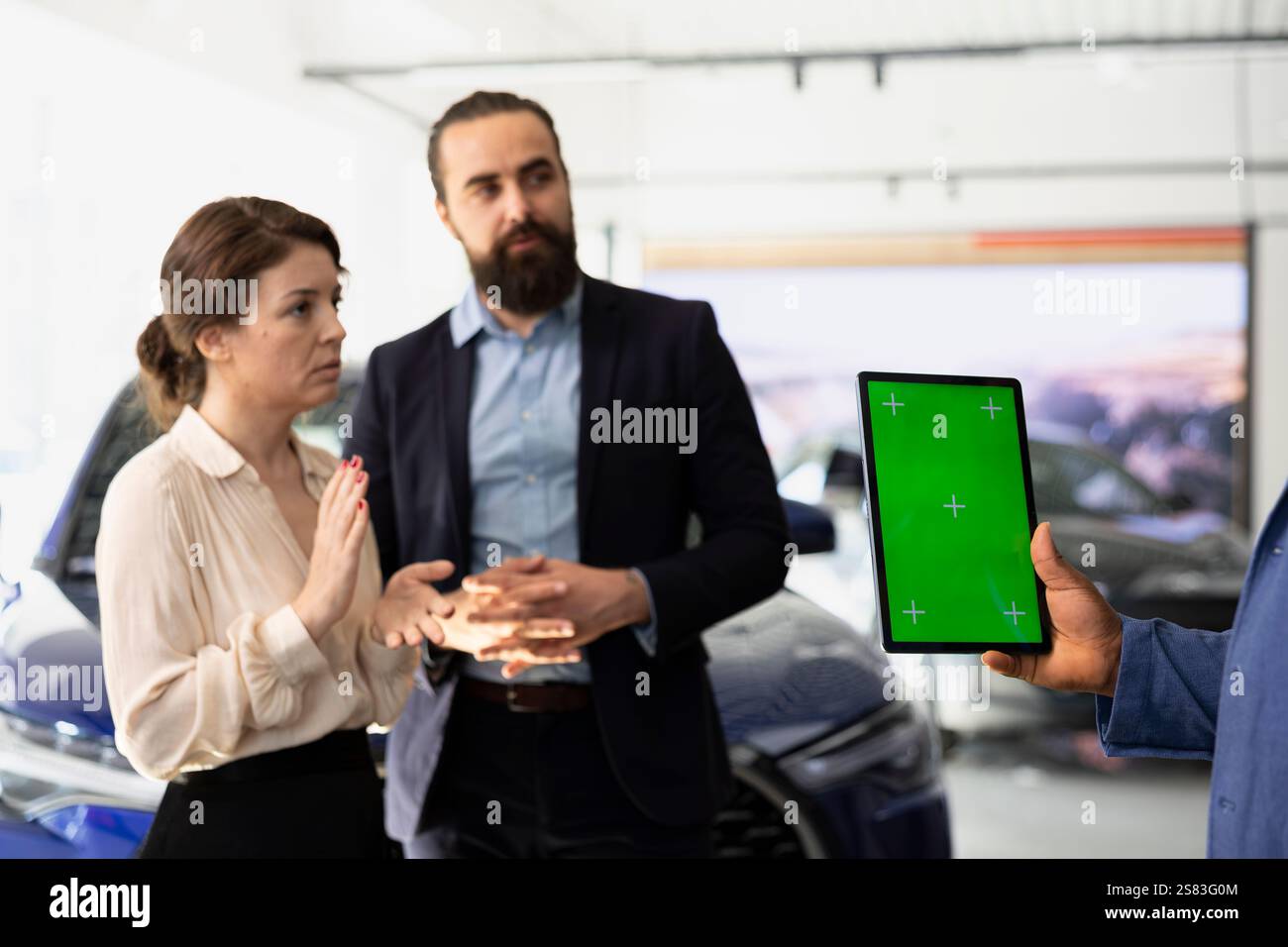 Car sales executive showcasing dealership vehicles to client using ...