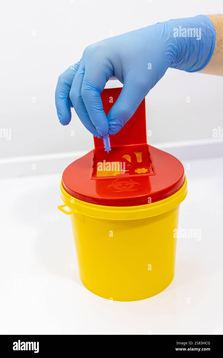 Old medicine syringes thrown into a medical waste container. The ...
