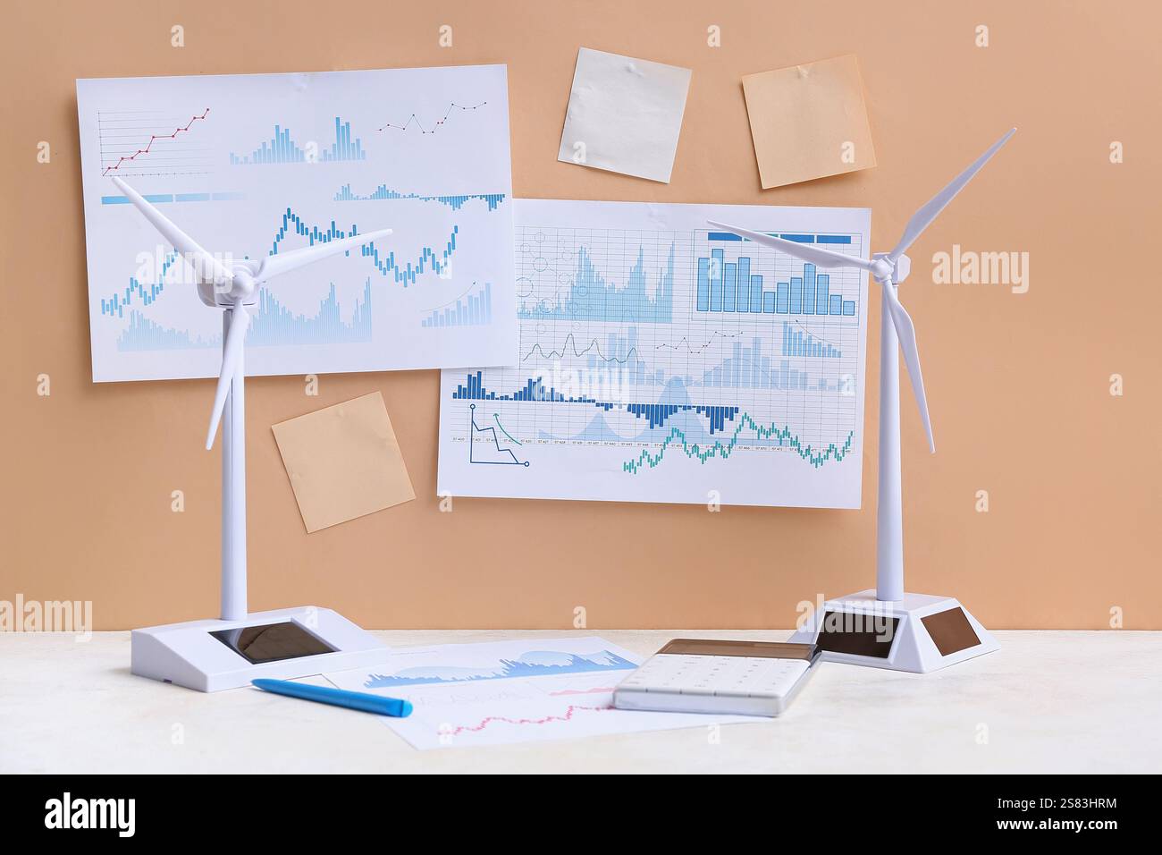 Diagrams with blank sticky notes and wind turbine models on table near ...