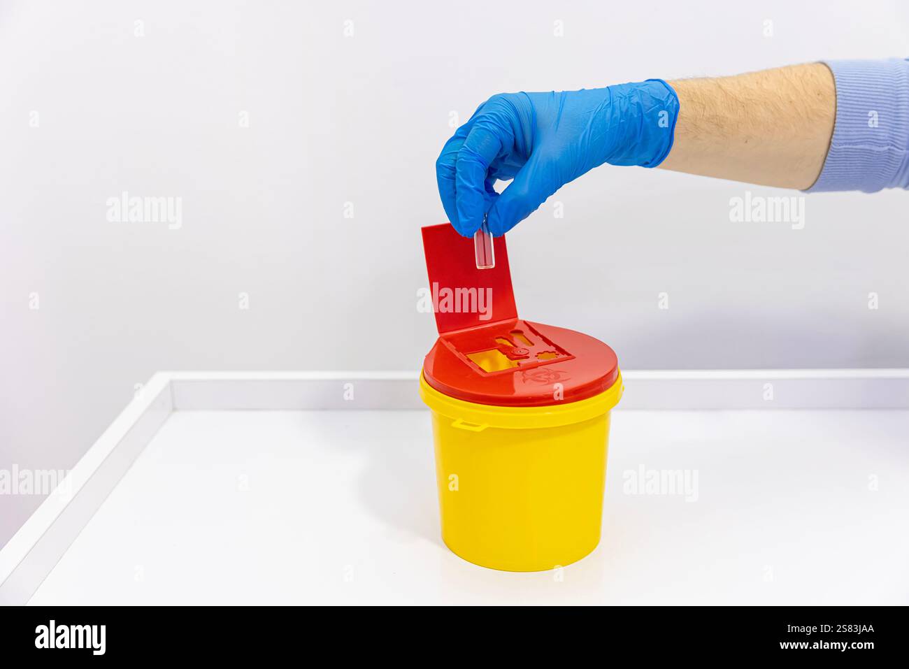 Old medicine syringes thrown into a medical waste container. The ...