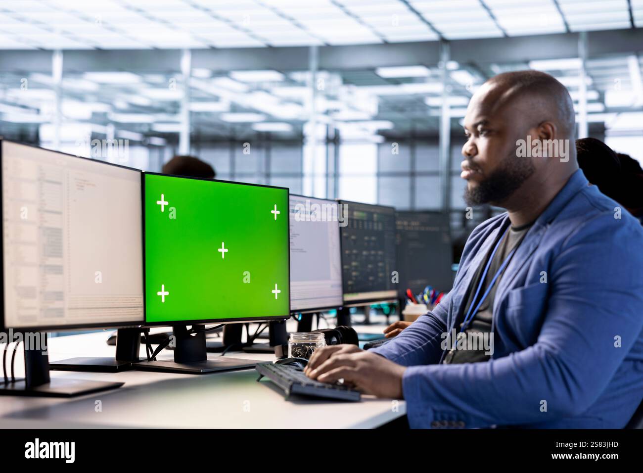 Software developer in data center using diagnostic tools on green screen PC to identify root ...