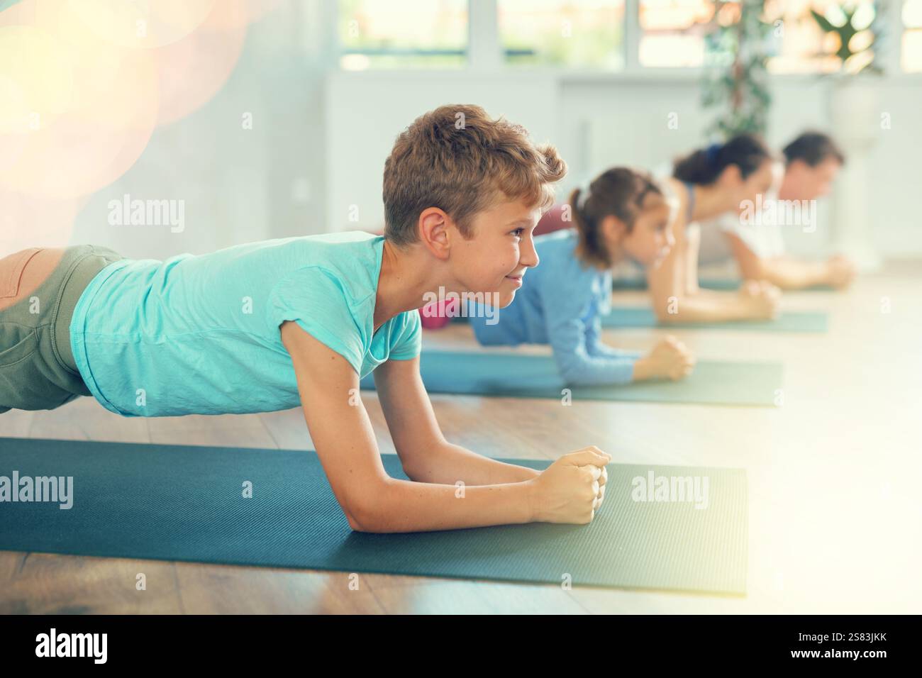 Little boy with his family practicing yoga in studio Stock Photo - Alamy