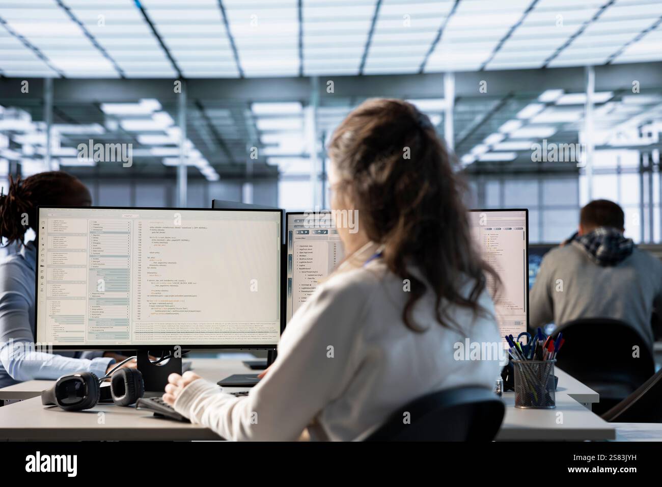 Technician in server hub ensuring valuable data remains shielded from potential threats using PC ...