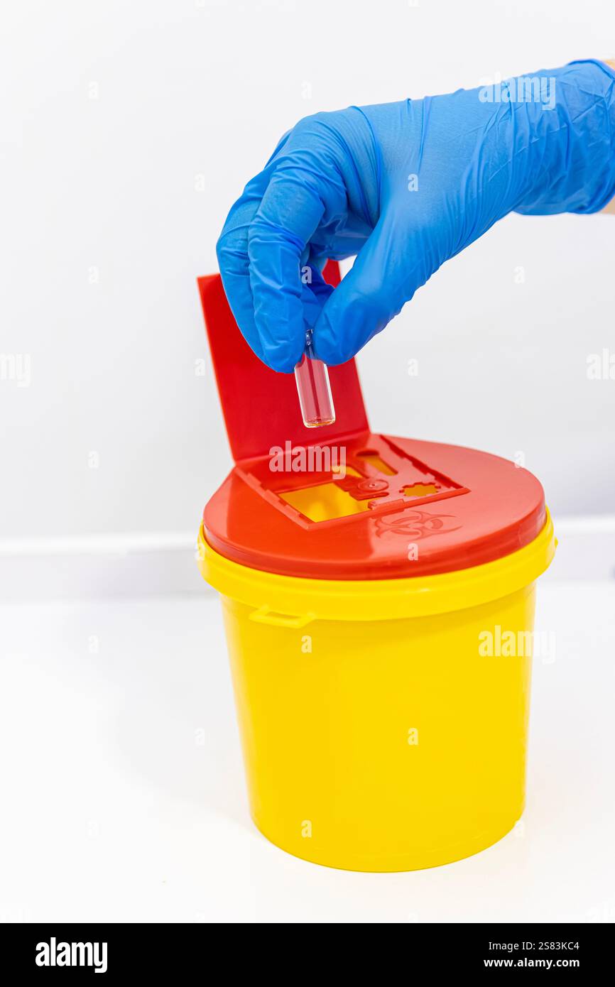 Old medicine syringes thrown into a medical waste container. The ...