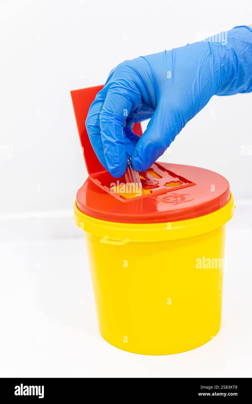 Old medicine syringes thrown into a medical waste container. The ...