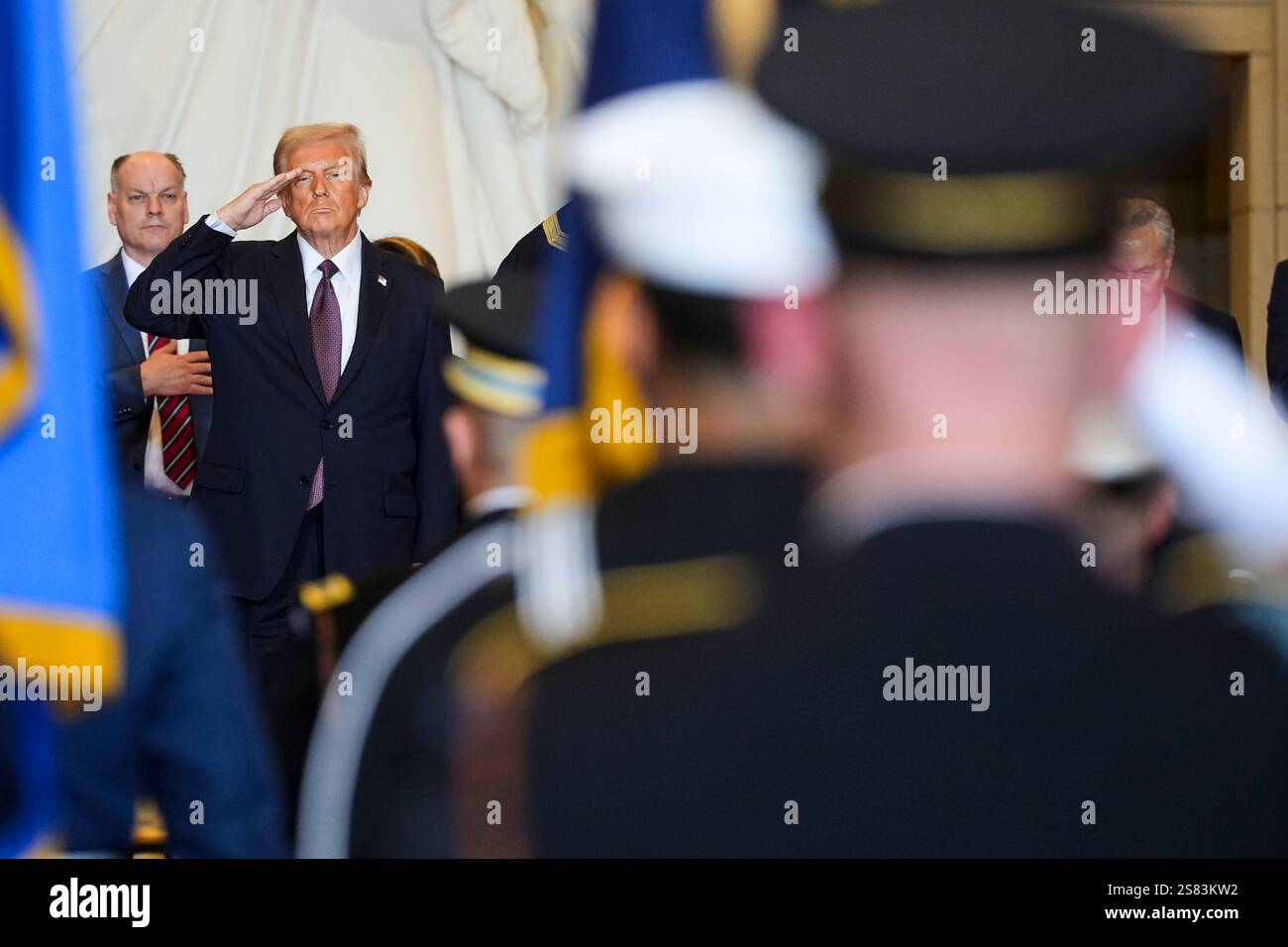 President Donald Trump salutes while on stage in Emancipation Hall at ...