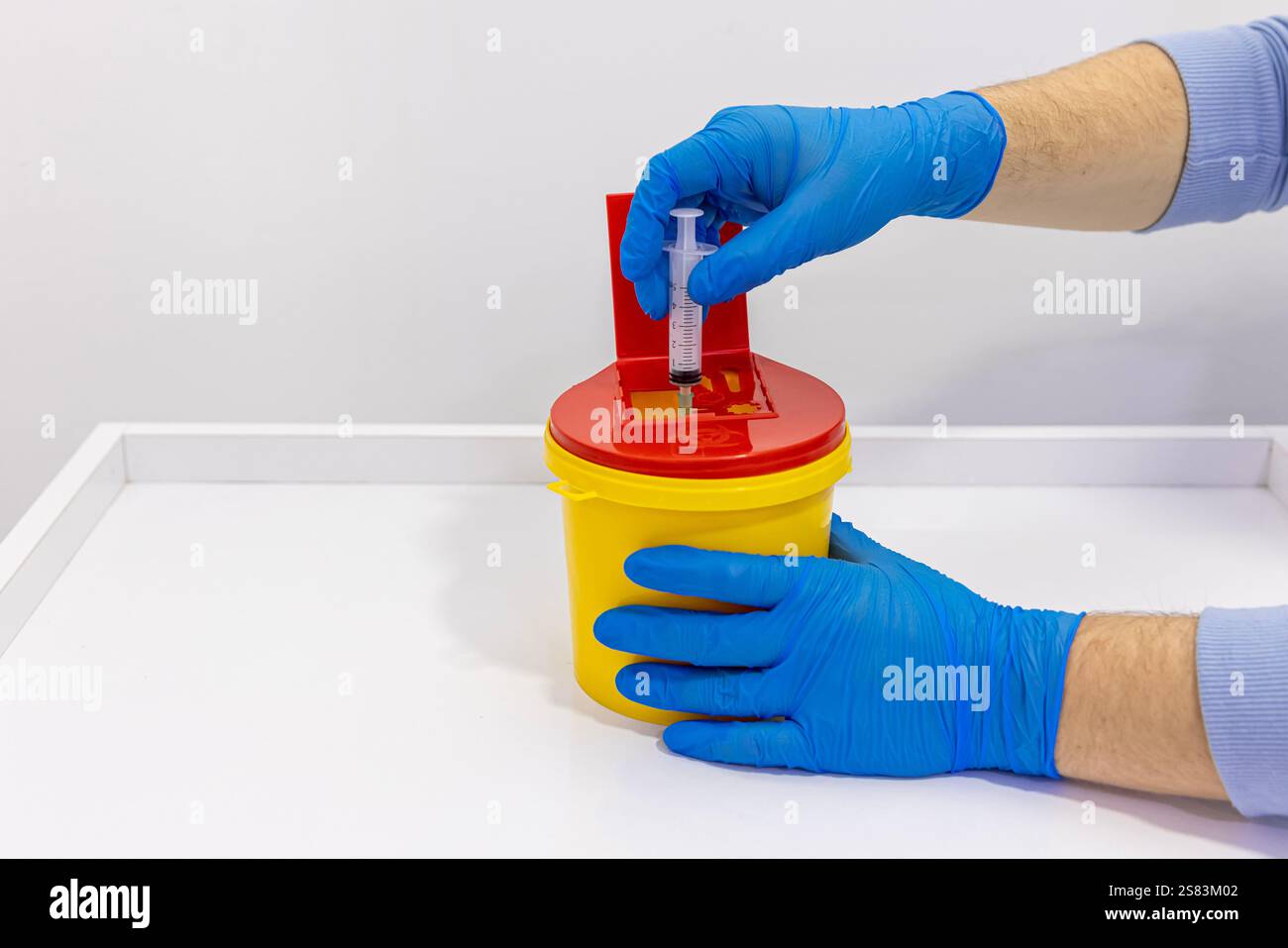 Old medicine syringes thrown into a medical waste container. The ...
