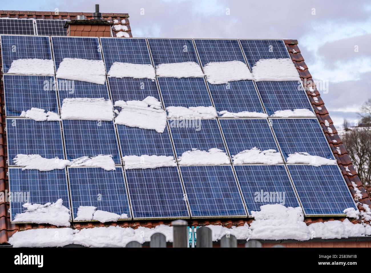 Solardach, Solarmodule auf einem Dach, im Winter, teils noch mit Schnee ...